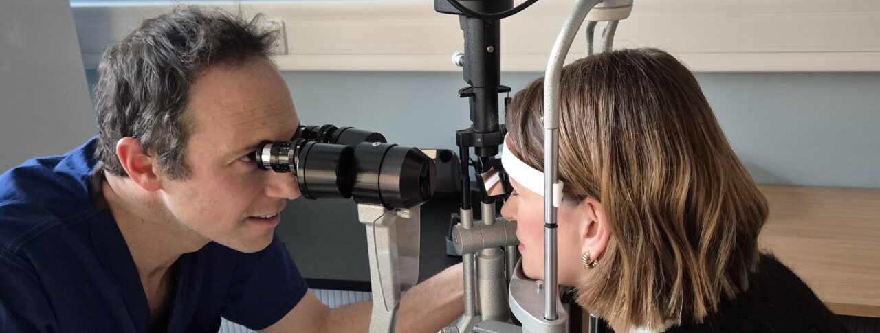 Dr Petrushkin examines Nicki's eyes using a slit lamp in clinic. Dr ...